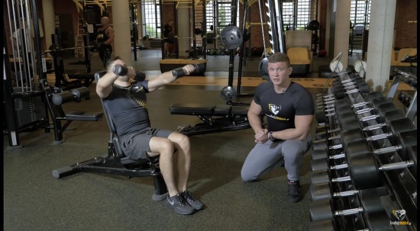 Unoszenie ramion z hantlami do przodu siedząc - BudujMase.pl